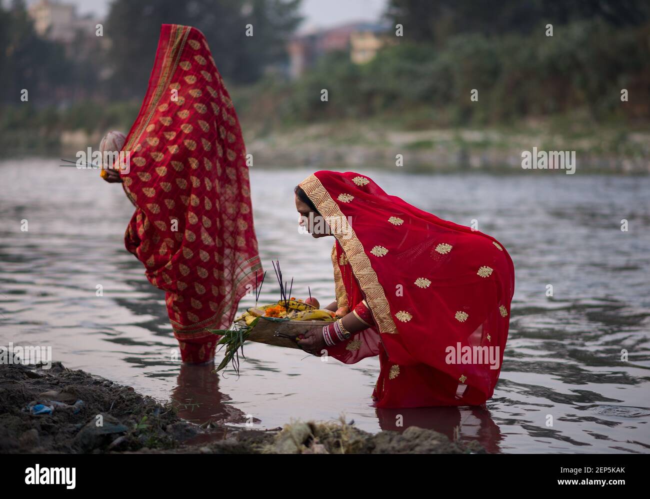 A devotee takes part in a ritual to worship the sun god during the ...