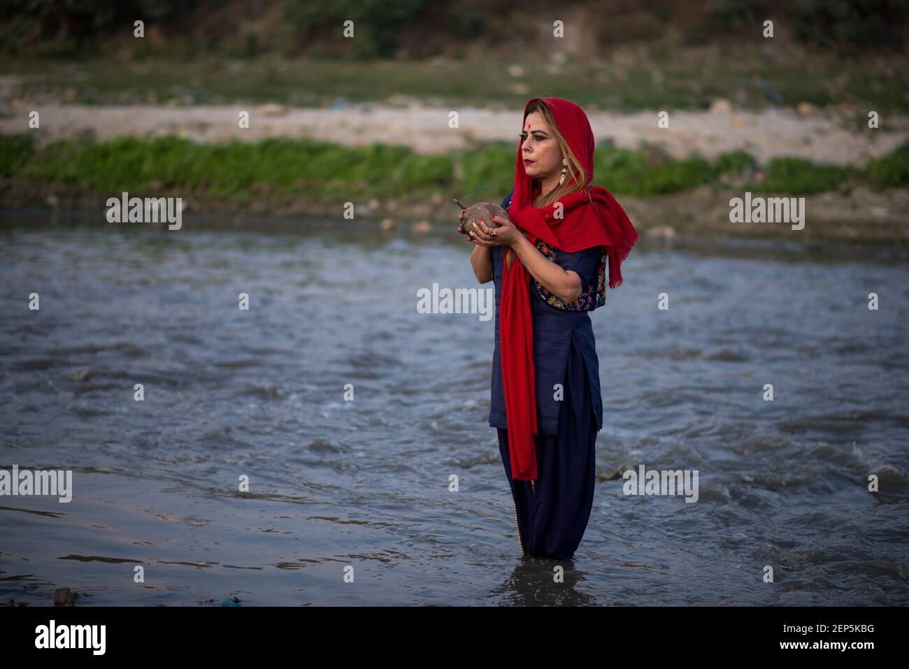 A devotee takes part in a ritual to worship the sun god during the ...