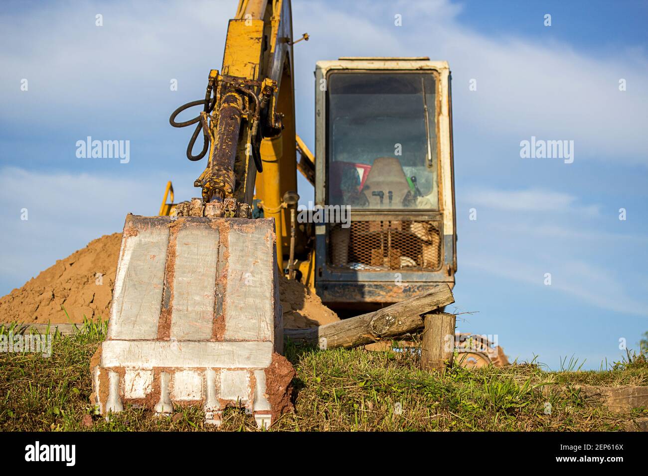 A large construction excavator of yellow color on the construction site ...