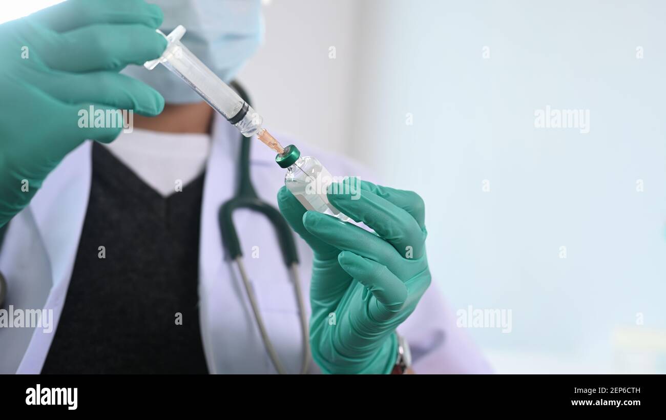 Close up view of doctor in hospital holding a syringe with liquid ...