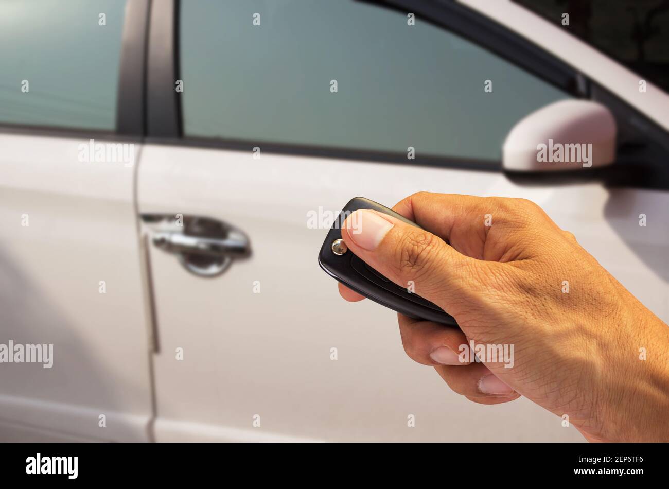 Man hand holding car key ready to start a new car with blurred car ...