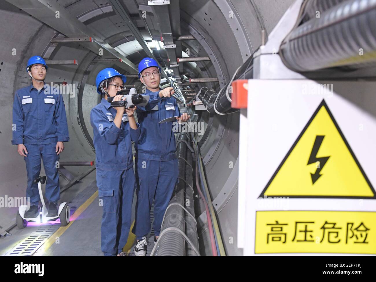 Chinese workers from the local power supply bureau patrol and inspect ...