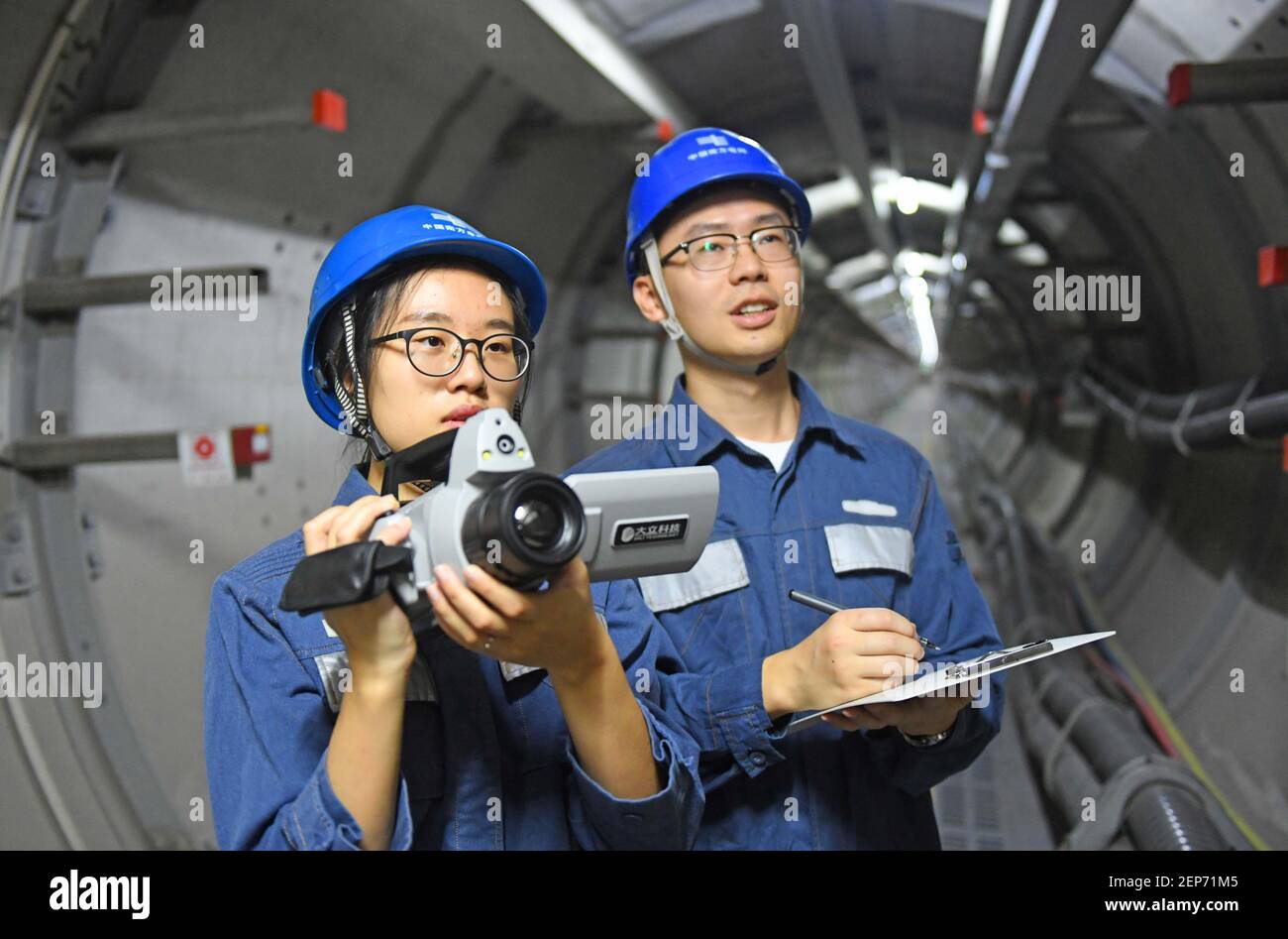Chinese workers from the local power supply bureau patrol and inspect ...