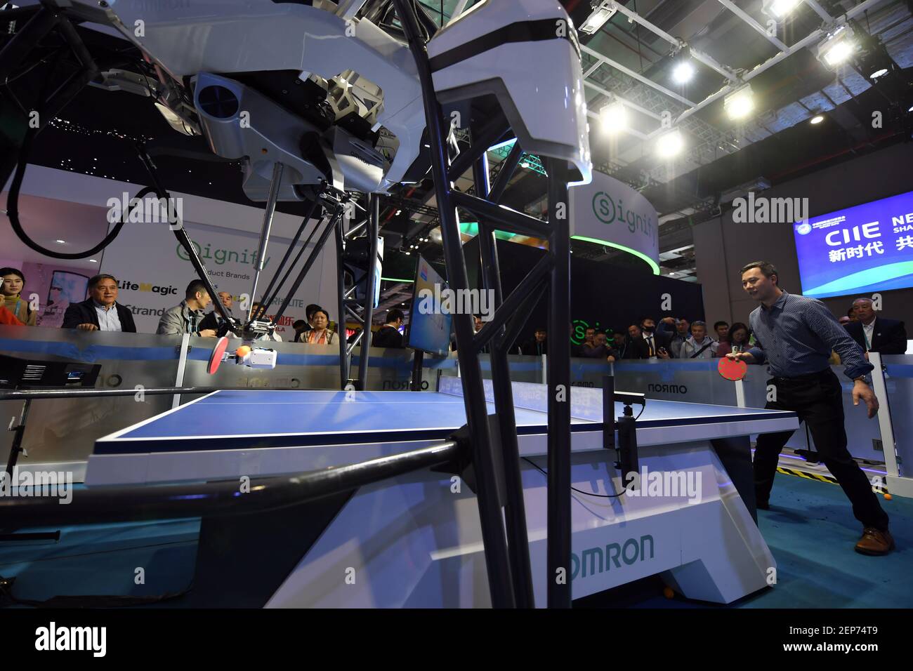 People watch Forpheus, the ping-pong robot designed by Omron playing ...