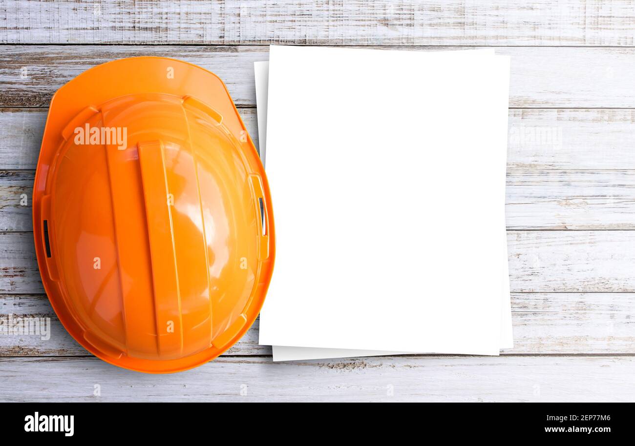 Top view Safety Engineer Helmet and blank paper on brown wooden table ...