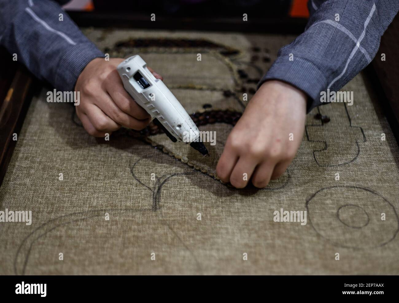 Hala Abu Kaoud puts coffee beans on a plate she made at home. Abu Kaoud ...