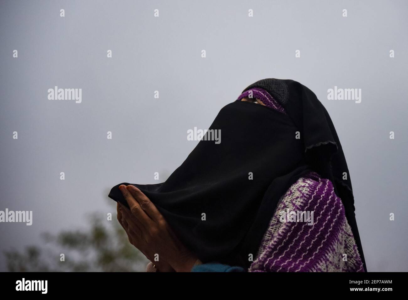 A Kashmiri woman devotee raises her hands while beseeching for ...