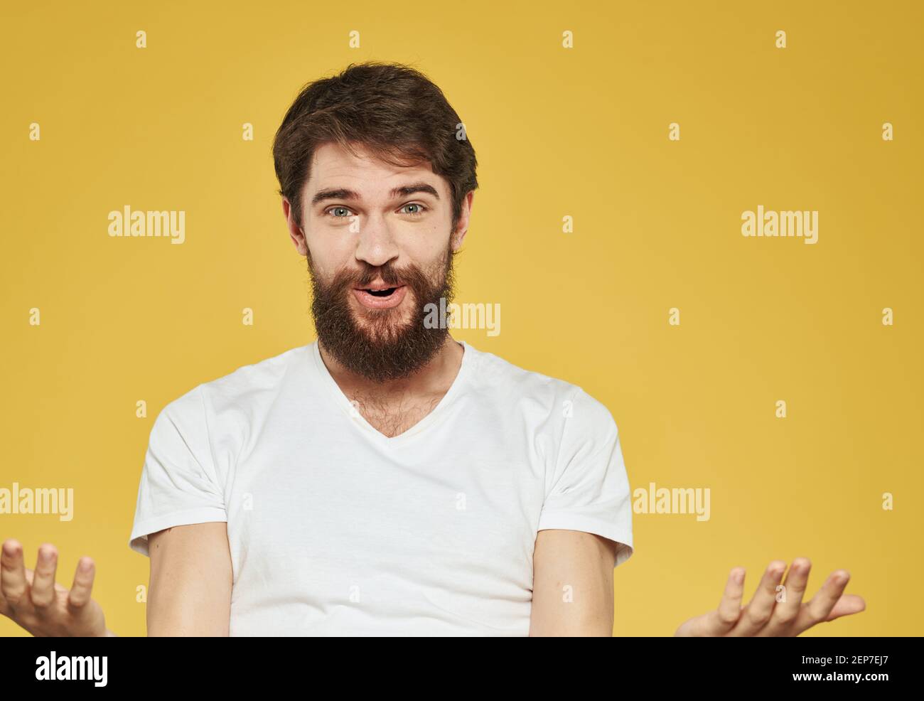 An energetic man on a yellow background gestures with his hands cropped ...