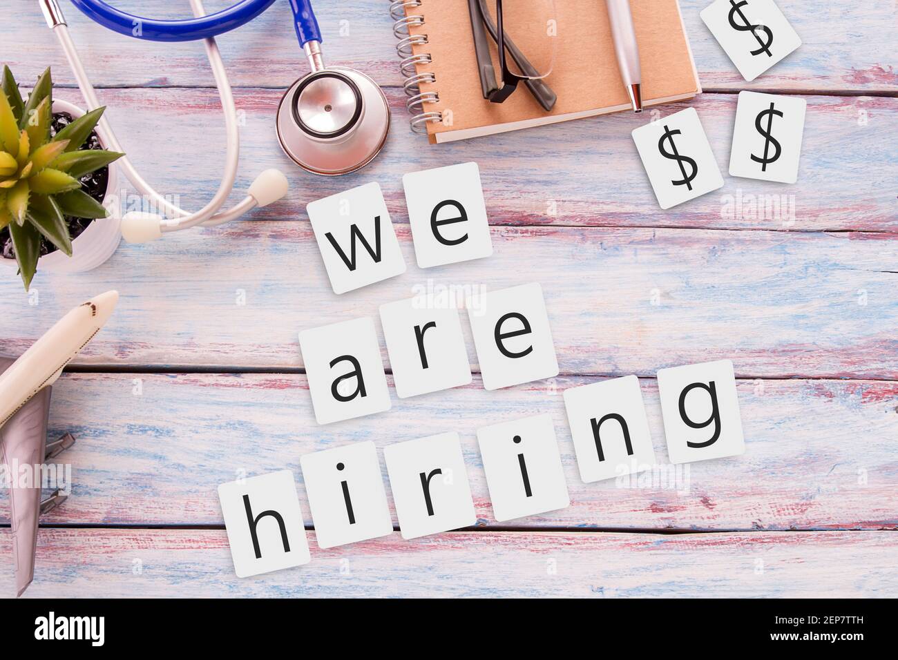 We are hiring text on sticky notes and blank notebook,glasses,airplane ...