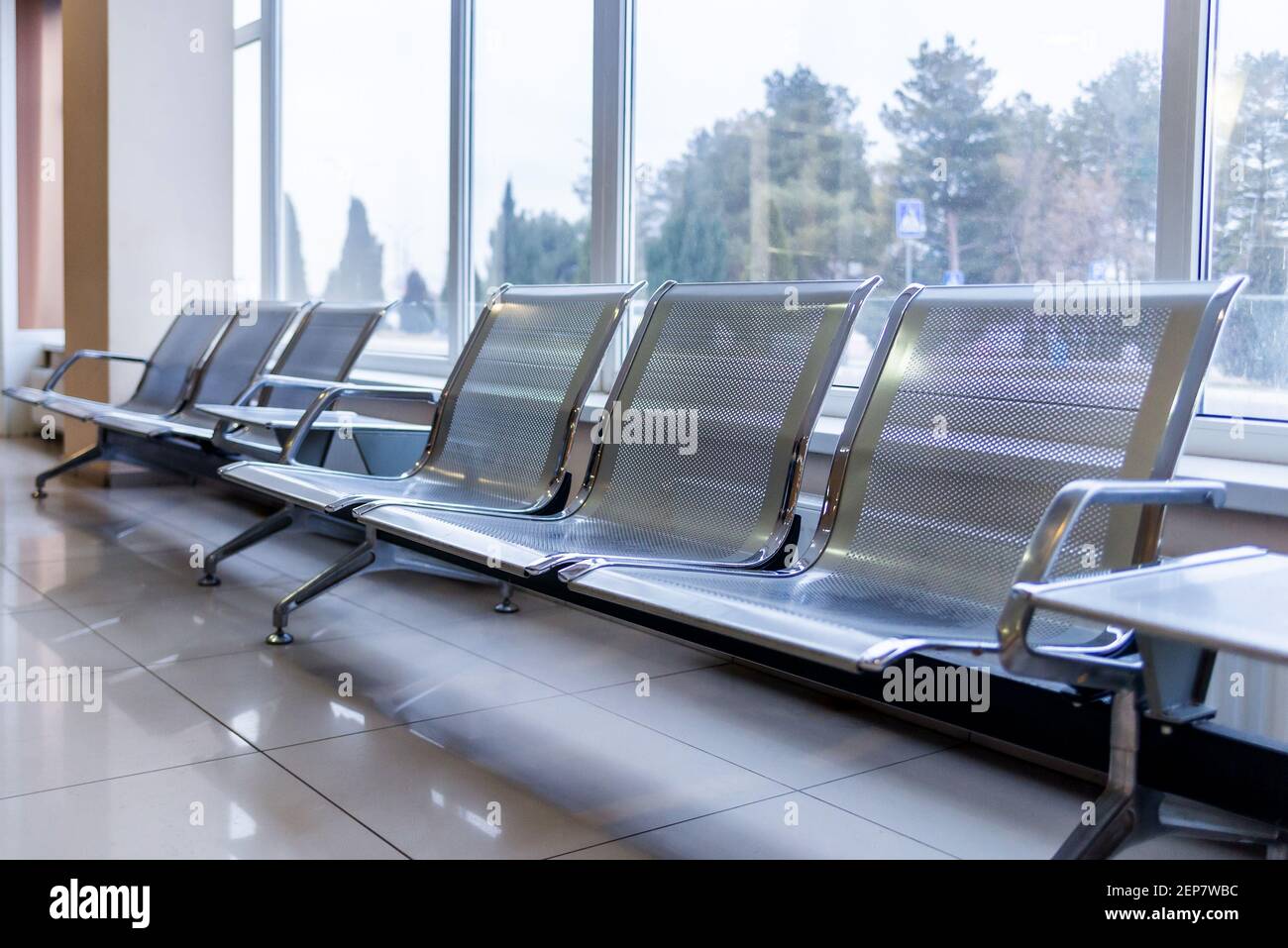 Airport gate waiting area with metal seats Stock Photo - Alamy