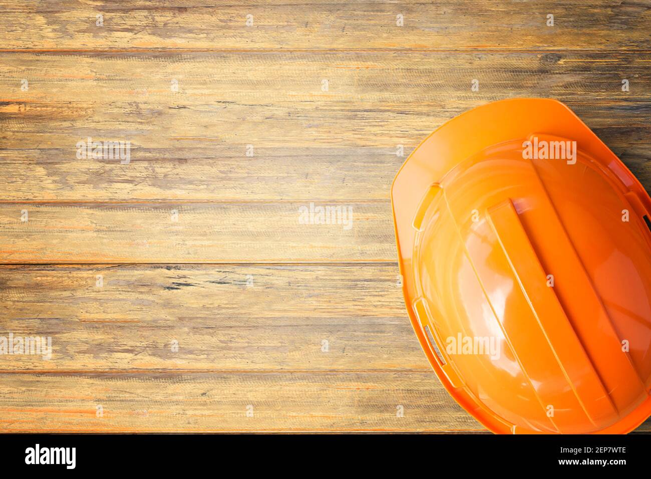 Orange safety engineer helmets on wood table background. Industrial ...