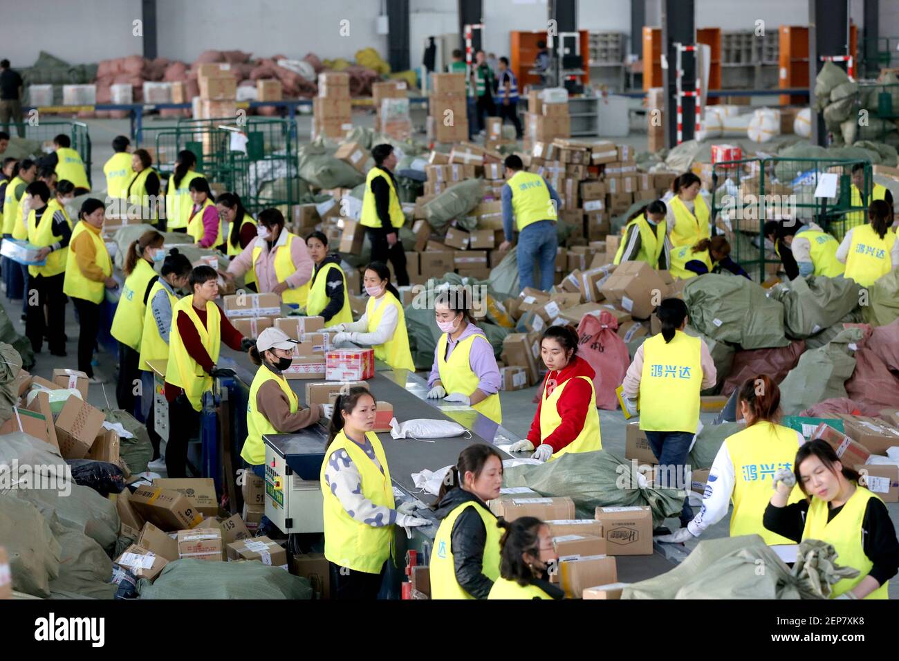 Workers at the EMS (Express Mail Service) logistics center sort out ...