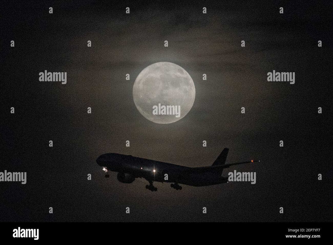 A United Airlines Boeing 777-200 passenger jet is illuminated by ...