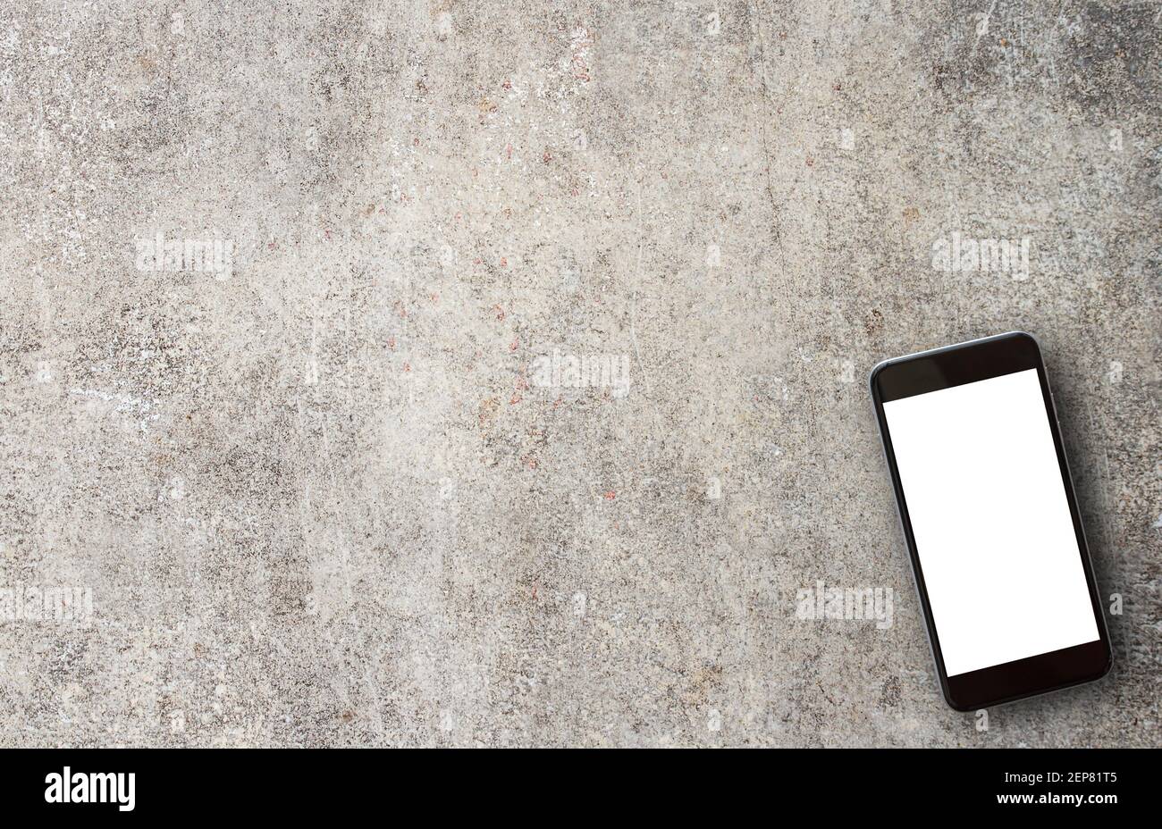 Mobile phone or smartphone with white screen on the cement floor. Copy ...