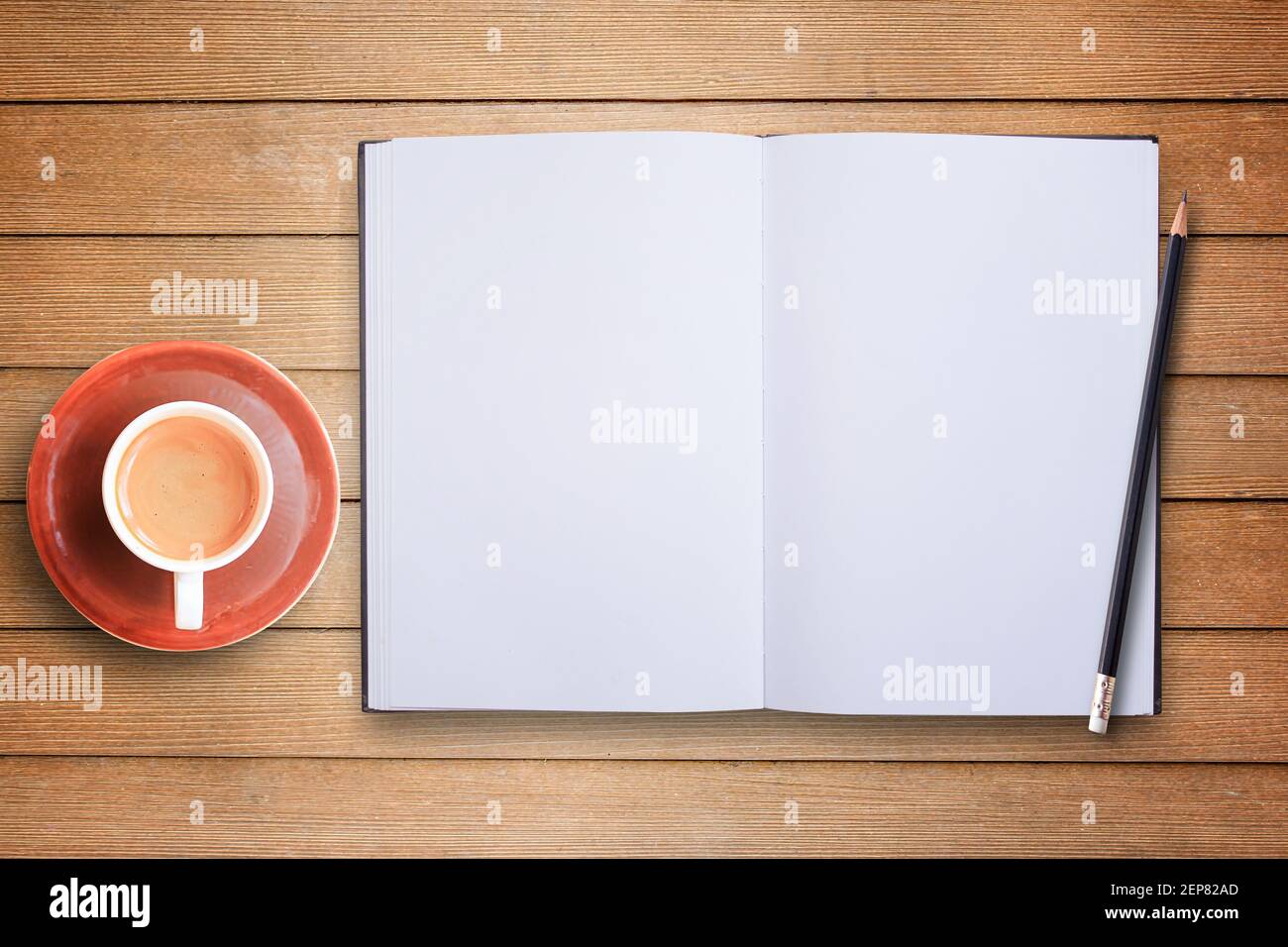 Notepad or notebook with pencil and cup of coffee on brown wood table ...