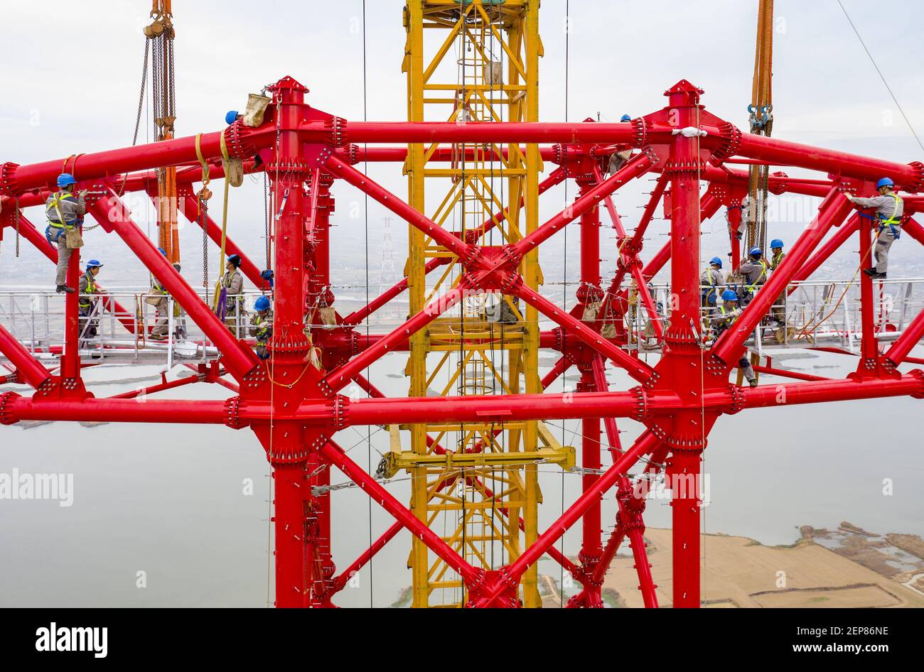 The workers are installing butt joint of electric tower cross arm at ...
