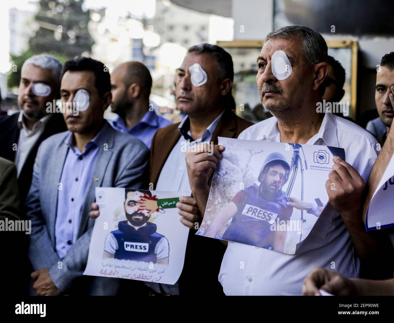Palestinian journalists holding placards cover one of their eyes during ...