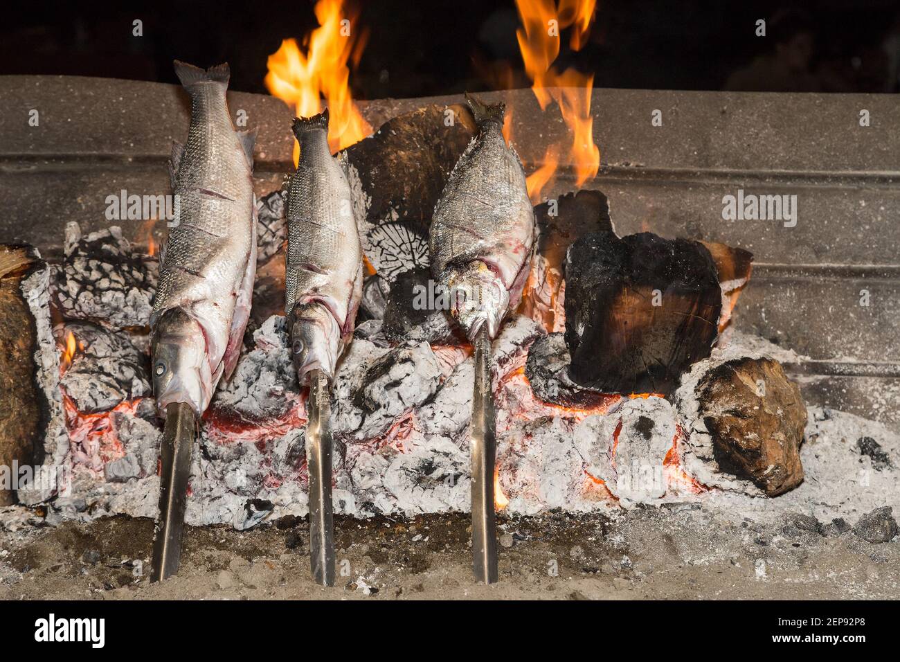 Cooking fish grilled over hot coals bonfire Stock Photo - Alamy