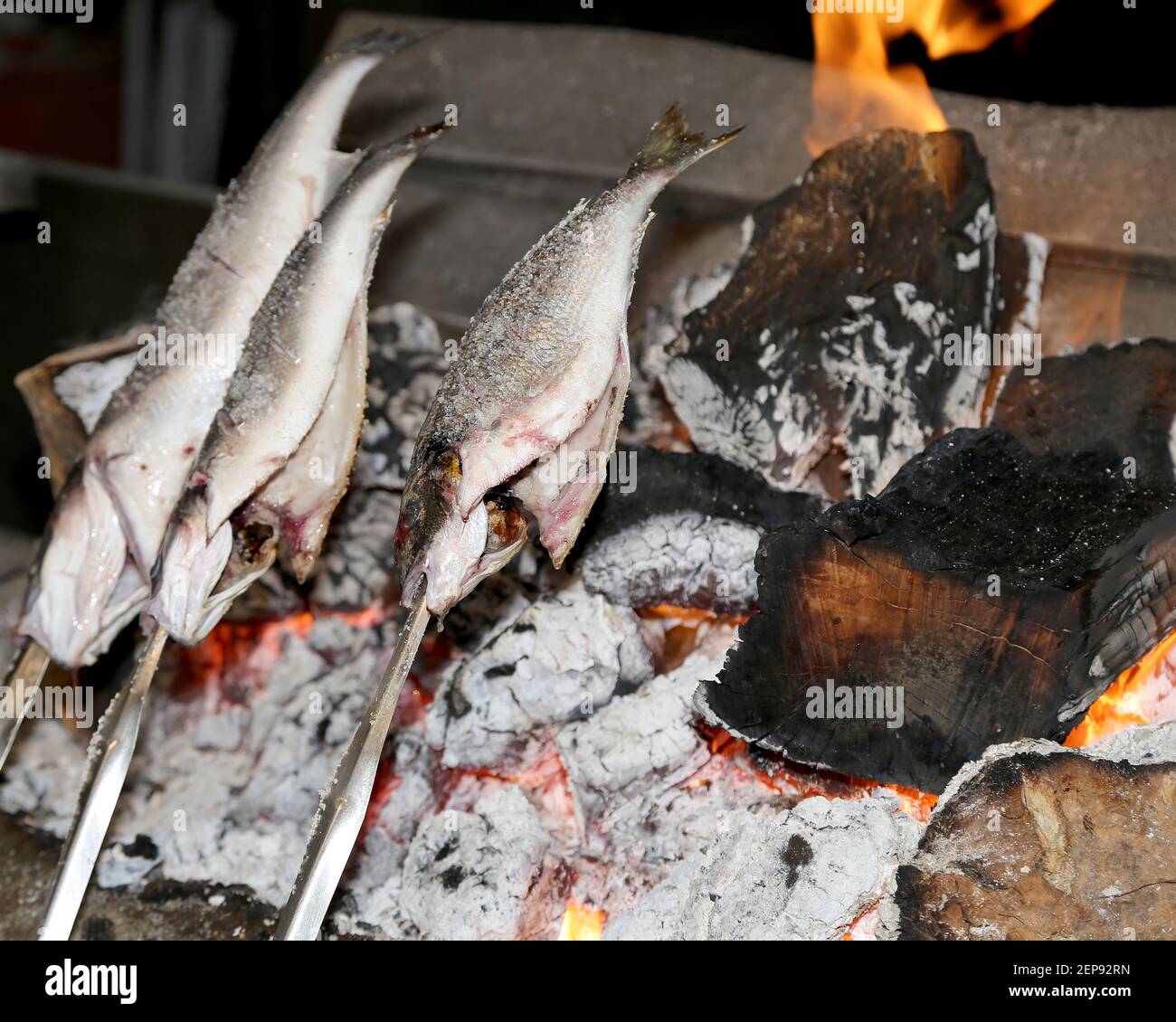 Cooking fish grilled over hot coals bonfire Stock Photo - Alamy