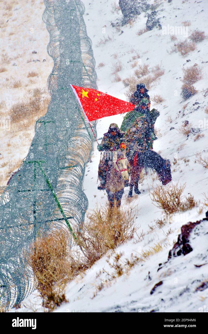 A group of border soldiers, carrying national flags, patrol a ...