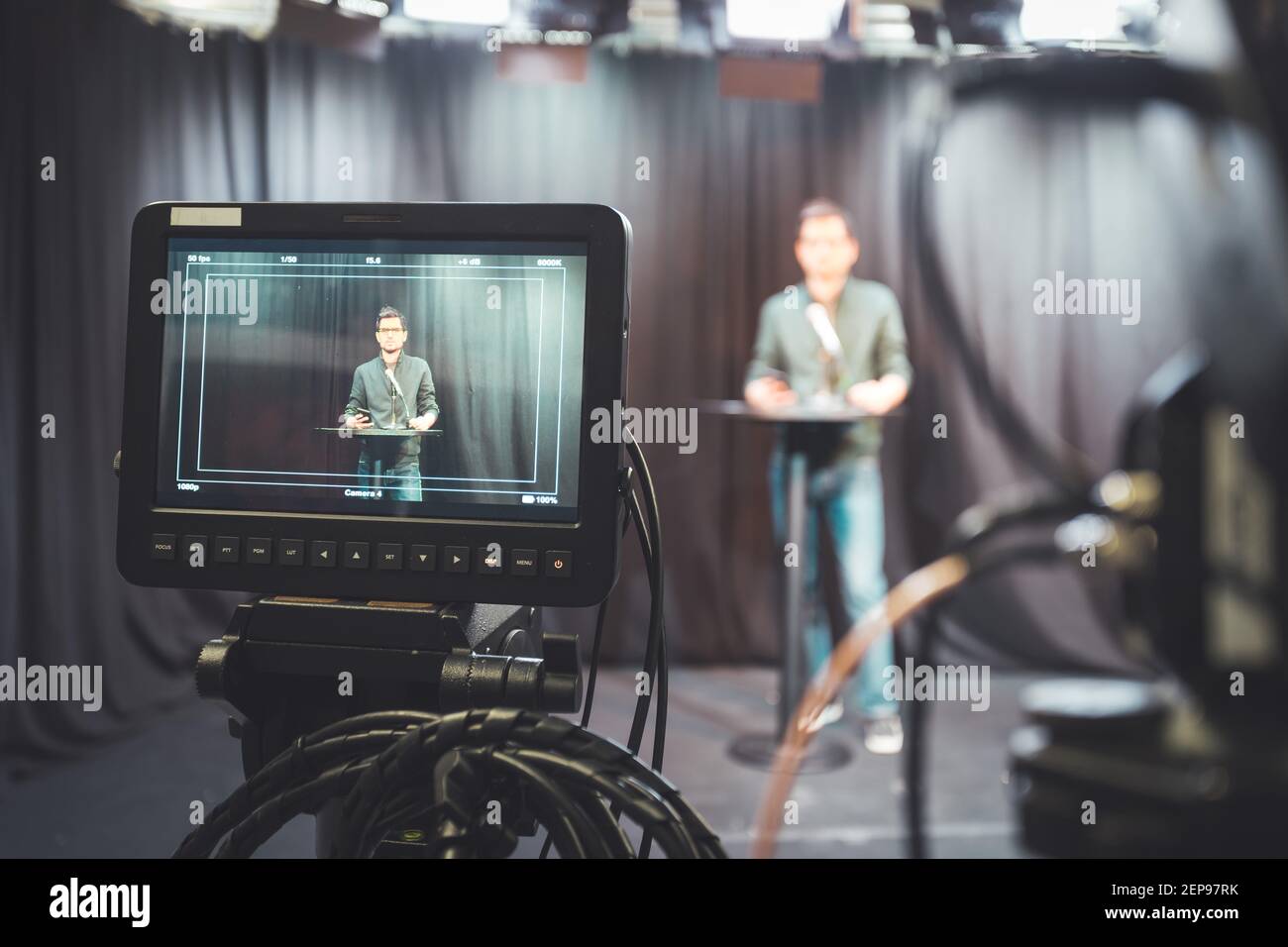 Male journalist in a television studio talks into a microphone, film ...