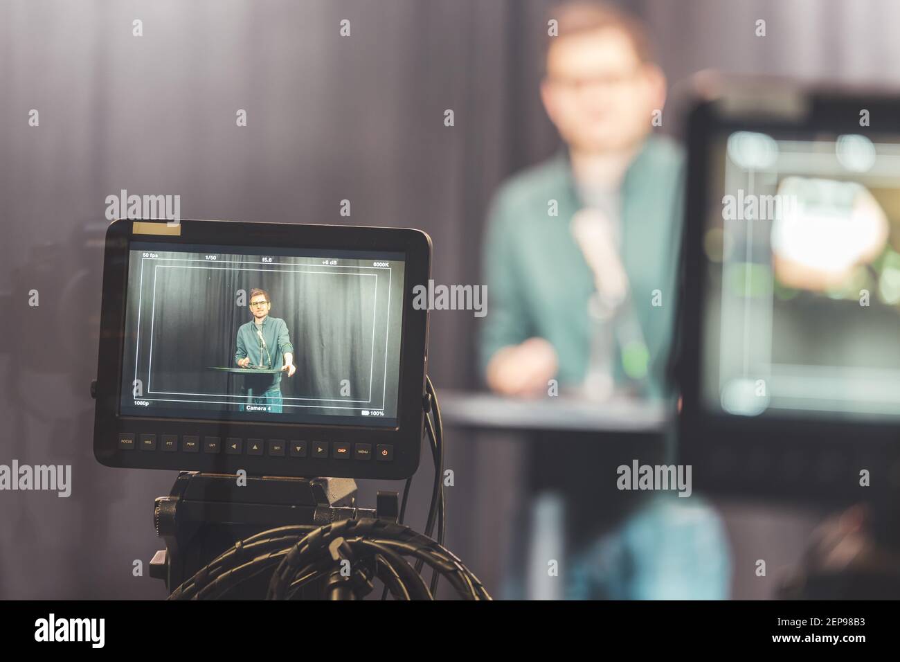 Male journalist in a television studio talks into a microphone, film ...