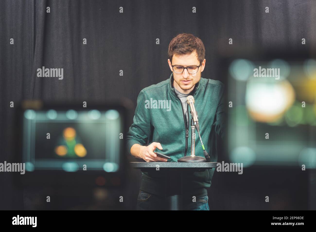 Male journalist in a television studio talks into a microphone, film ...