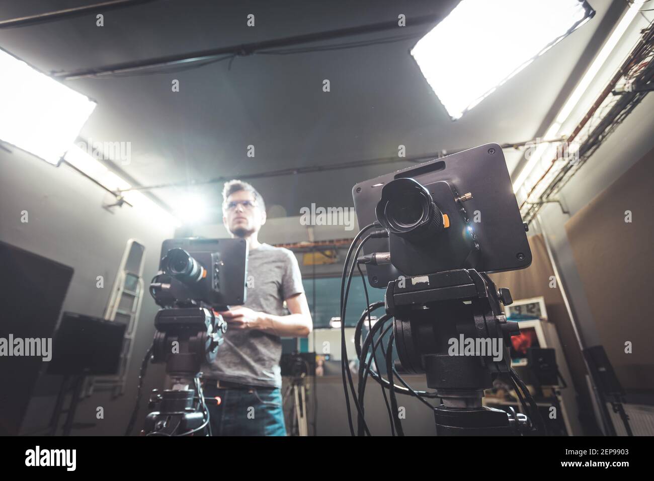 Male cameraman is operating a film camera in a television recording ...