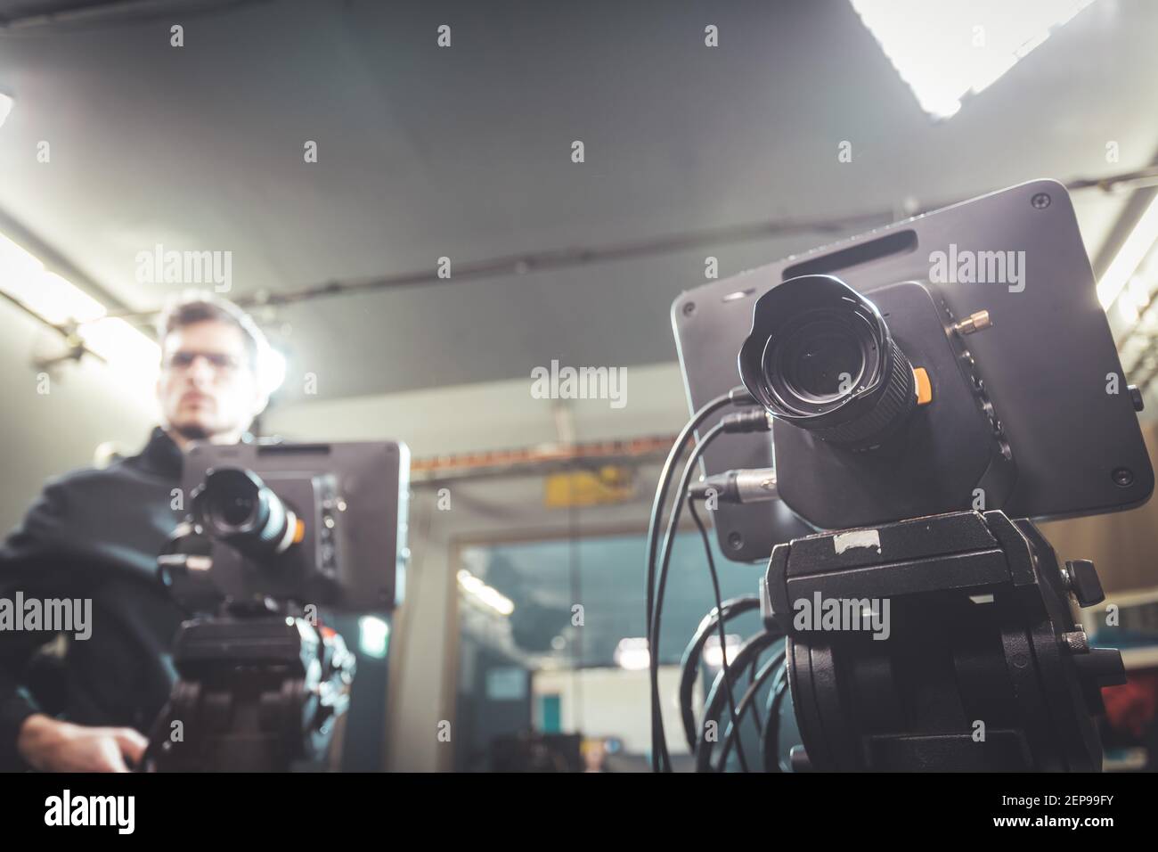 Male cameraman is operating a film camera in a television recording ...