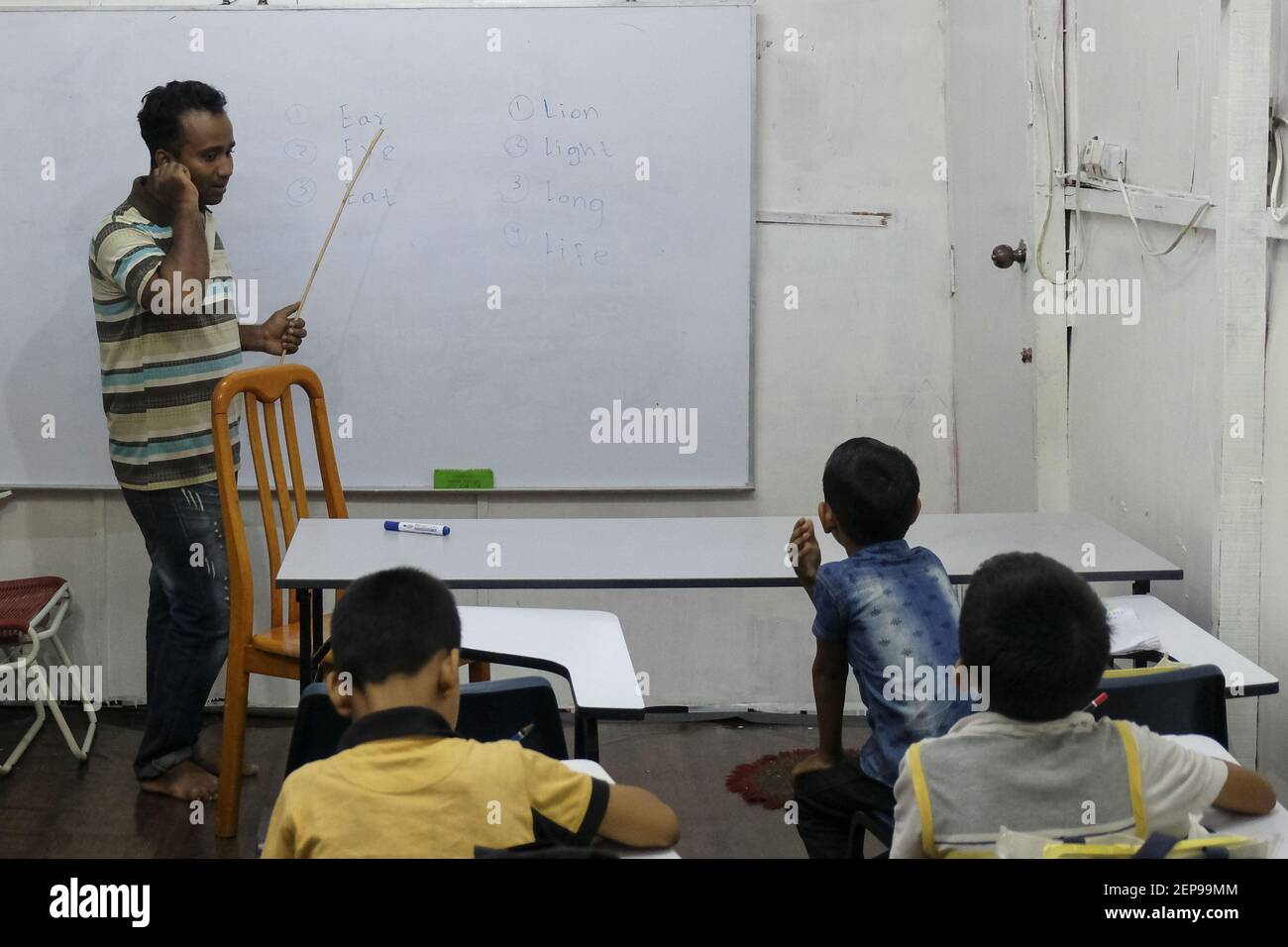 A volunteer teacher with kids in class at the academy. Rohingya English Academy is a learning ...