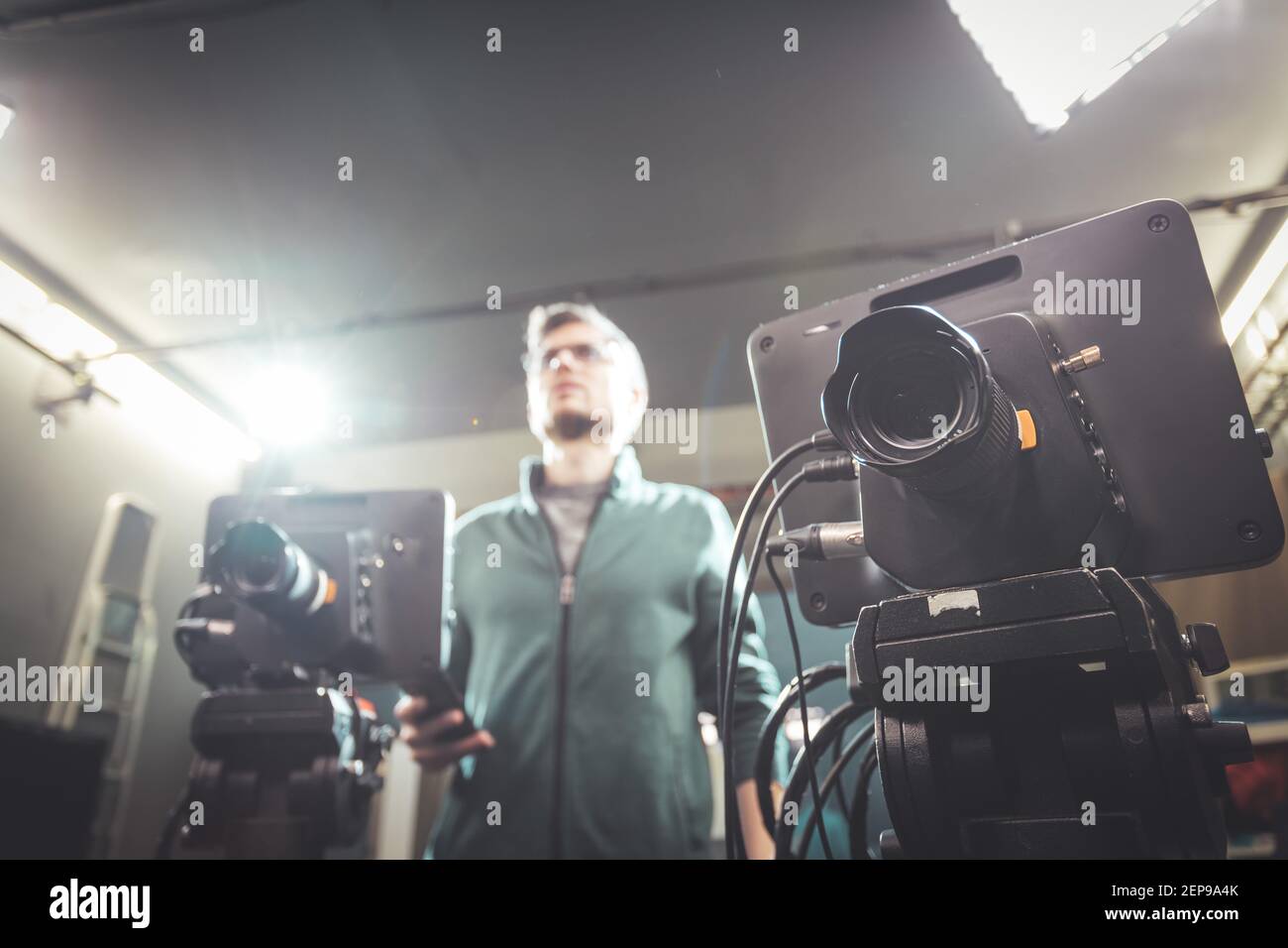 Male cameraman is operating a film camera in a television recording ...