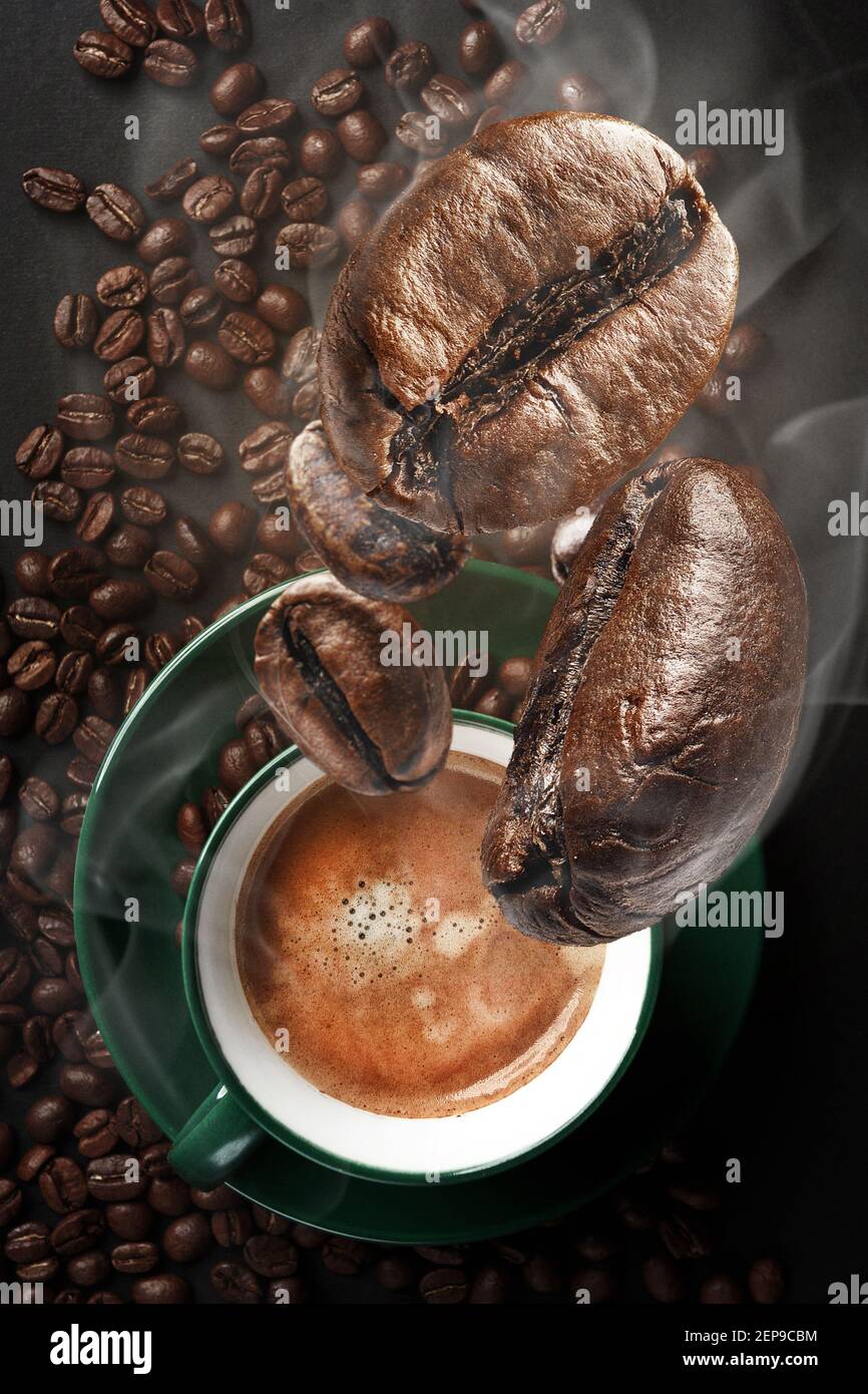 coffee beans fall in a cup with coffee Stock Photo - Alamy