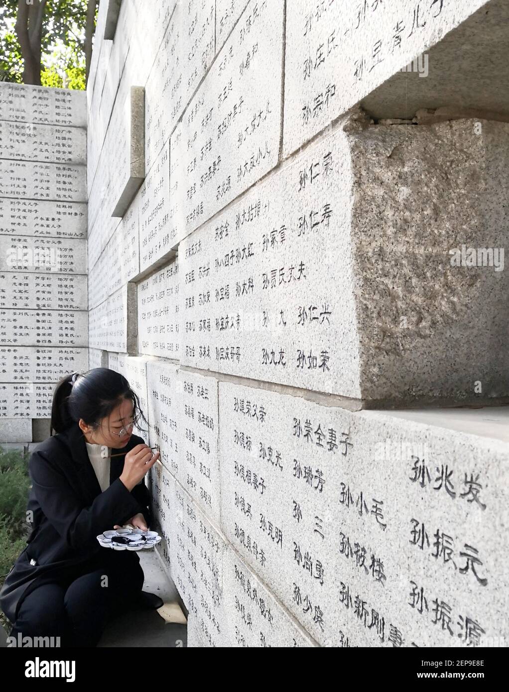 Volunteers from local universities trace the names of victims, who were ...