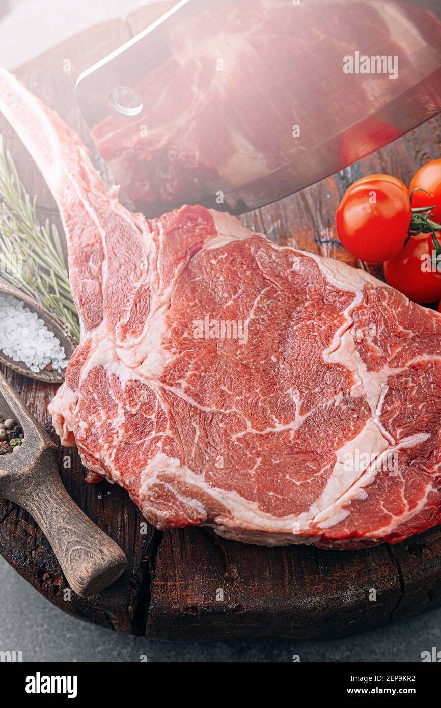 on a wooden block for meat a fresh raw tamahawk steak or a cowboy steak ...