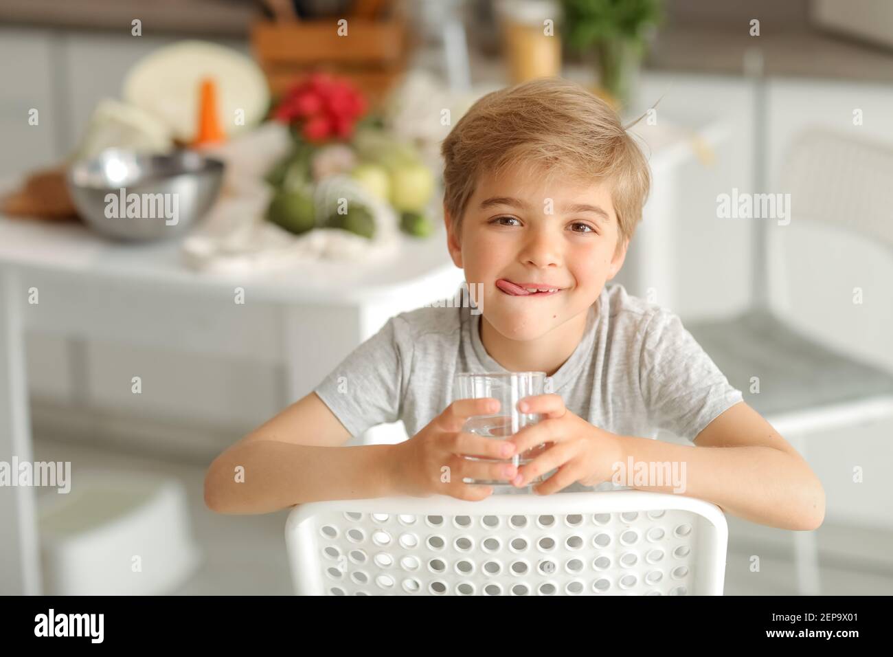 Beautiful baby 8 years sits on a chair and looks pmo into the camera ...