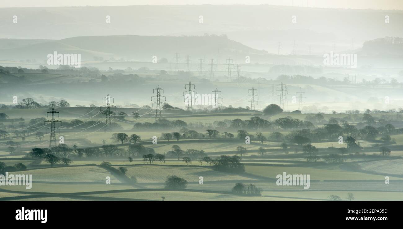 A line of electricity pylons running across open countryside in the ...