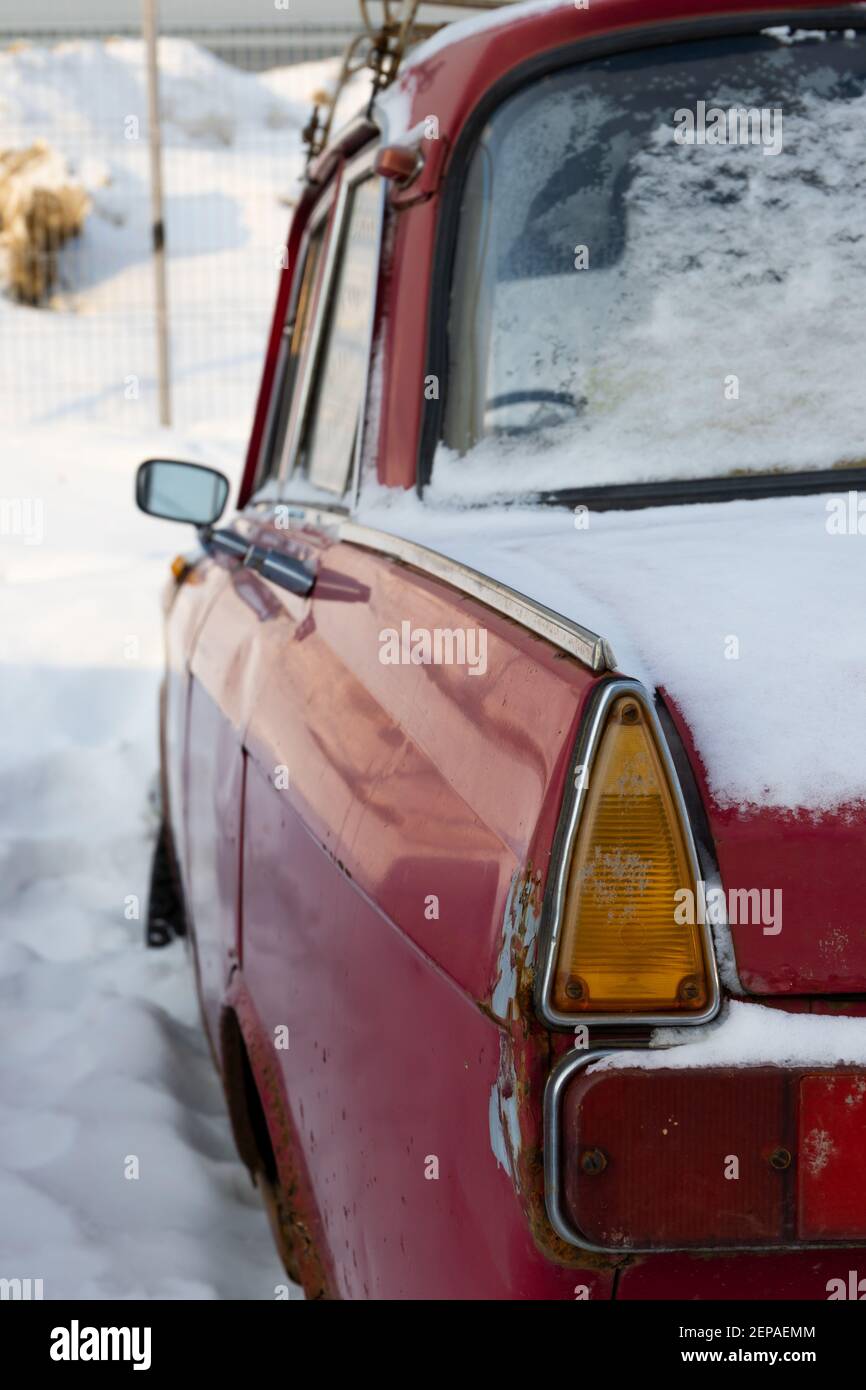 old broken vintage red rusty retro car parked in winter on snow ...