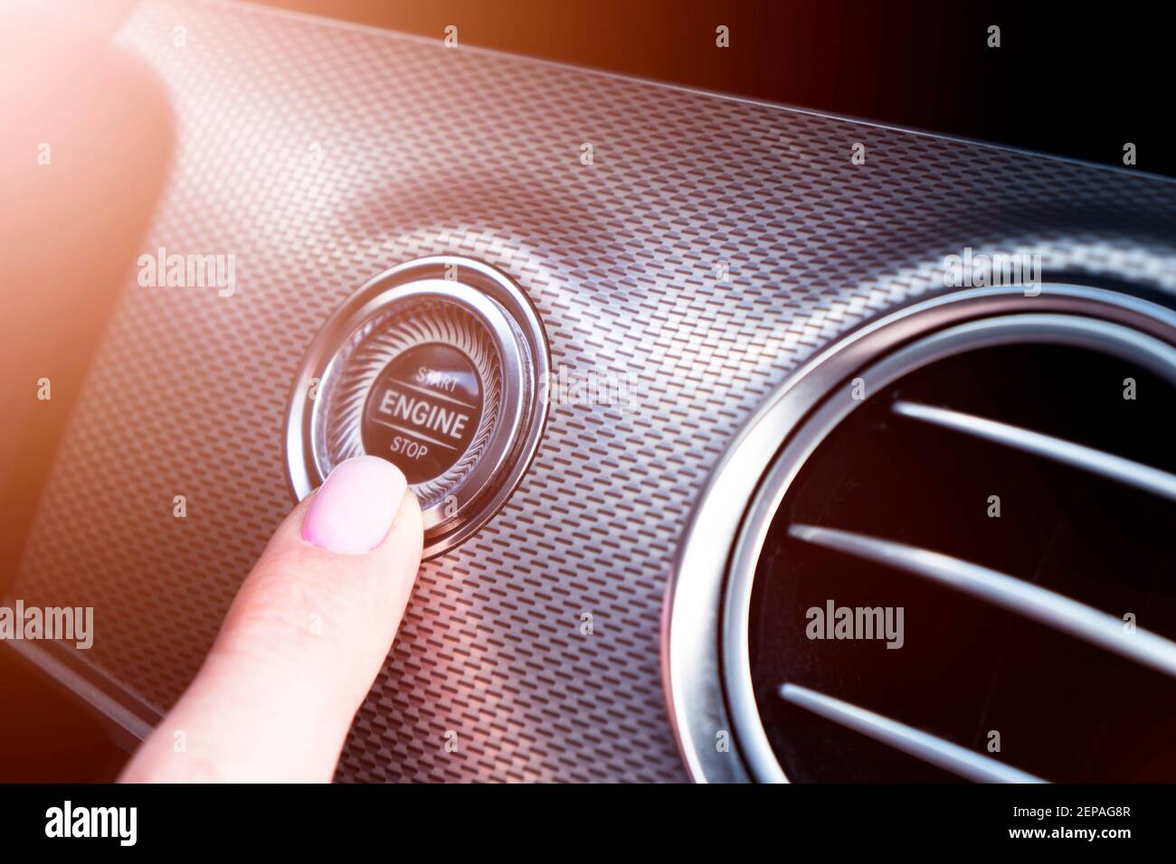 Car driver starting the engine with start stop engine button. Finger ...