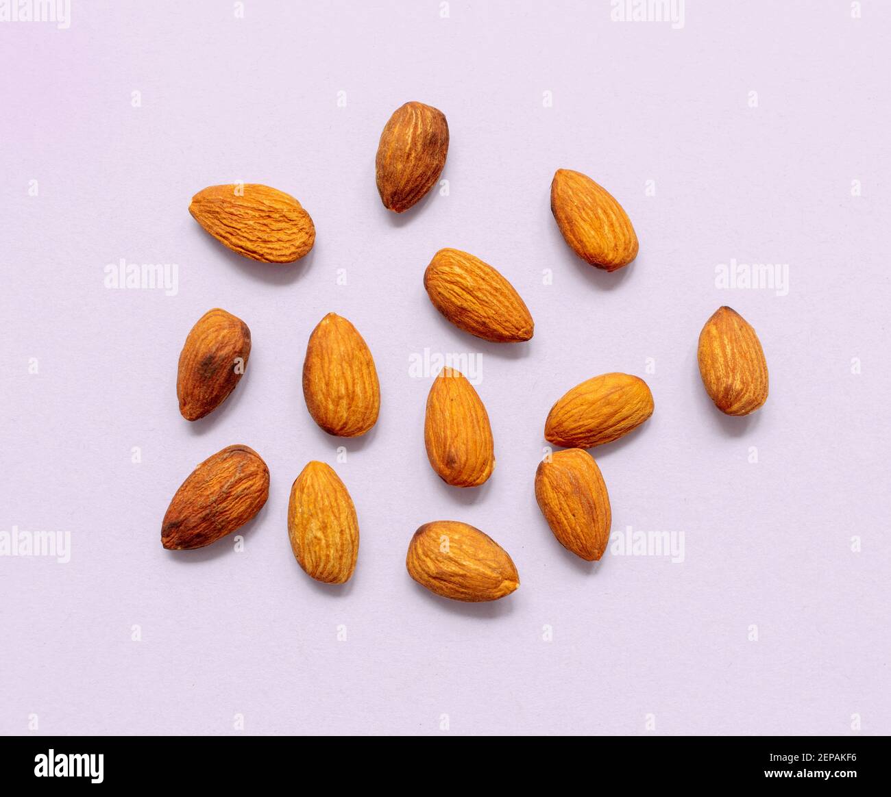almonds on light purple paper background, top view Stock Photo - Alamy