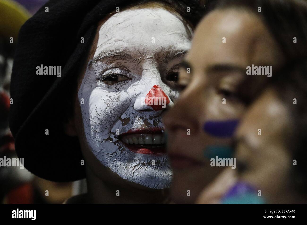 A woman her face painted as a clown attends the International Day for ...
