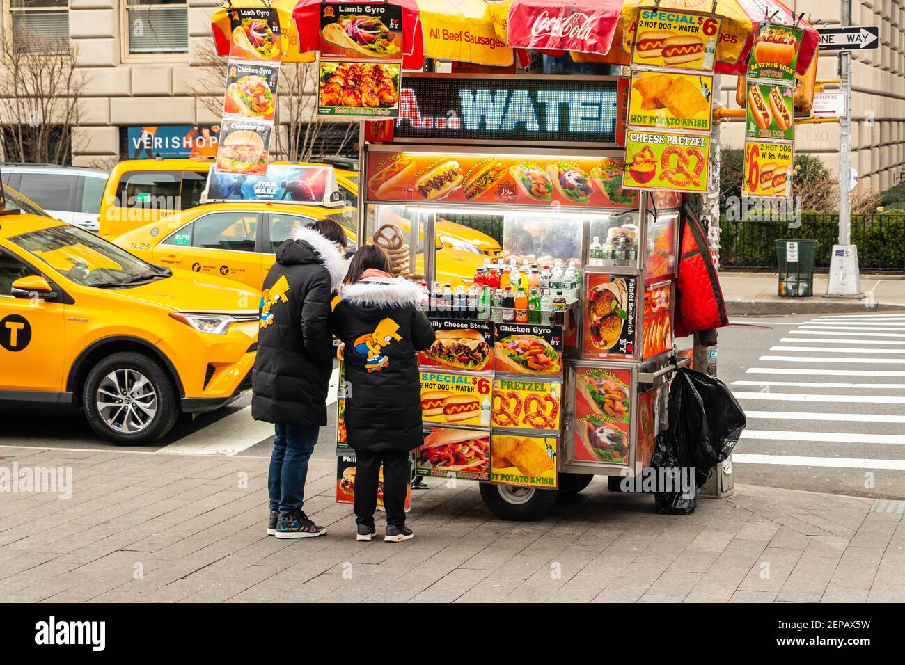 asian couple in identical Simpsons coats at food stands outside of New ...