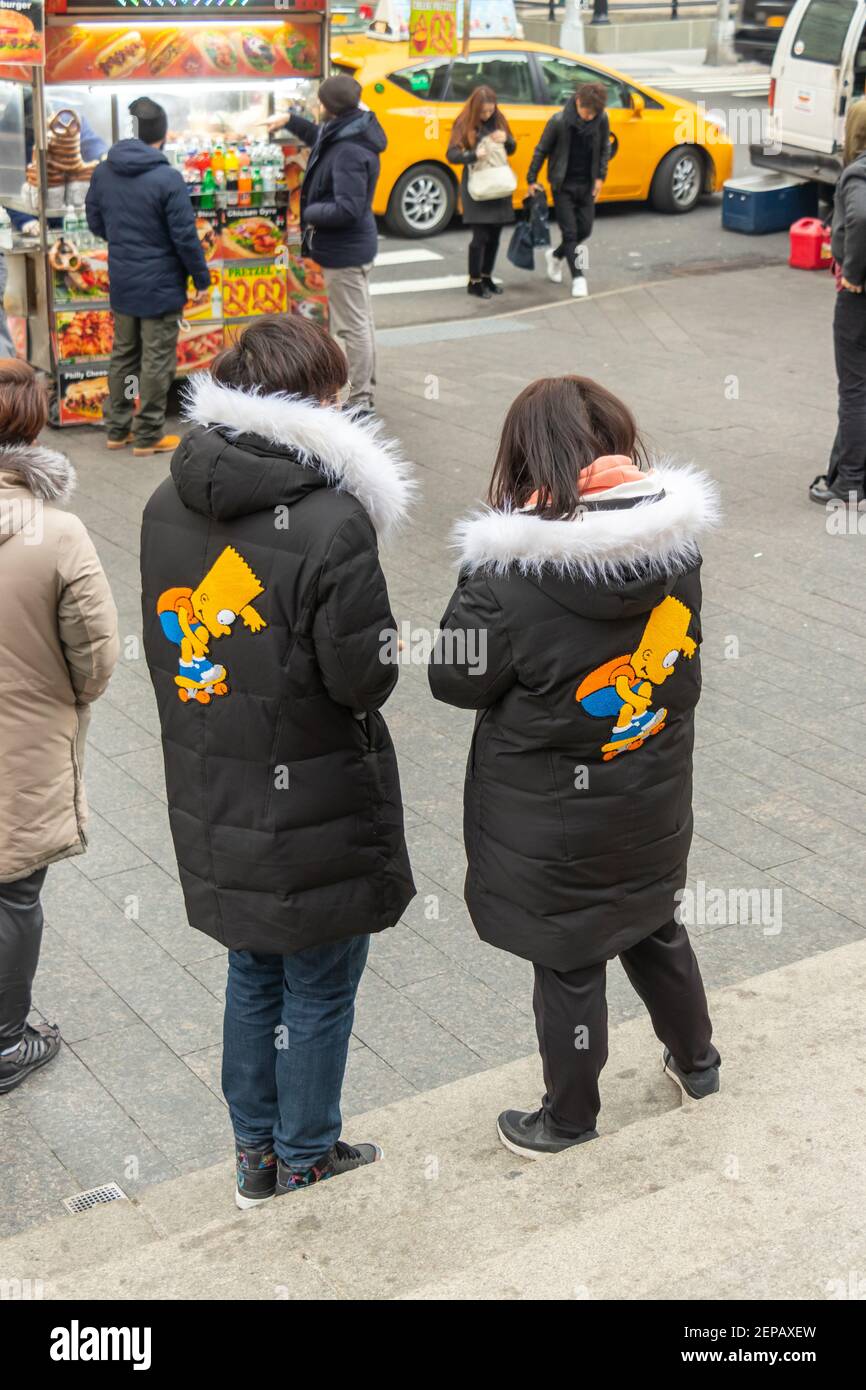 asian couple in identical Simpsons coats at food stands outside of New ...
