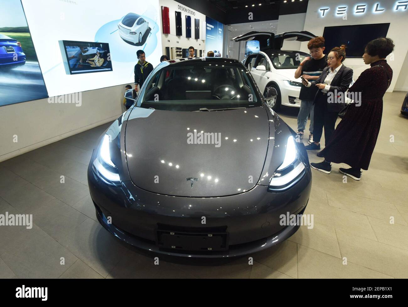 People look at a Chinese-manufactured Tesla Model 3 electric car on ...