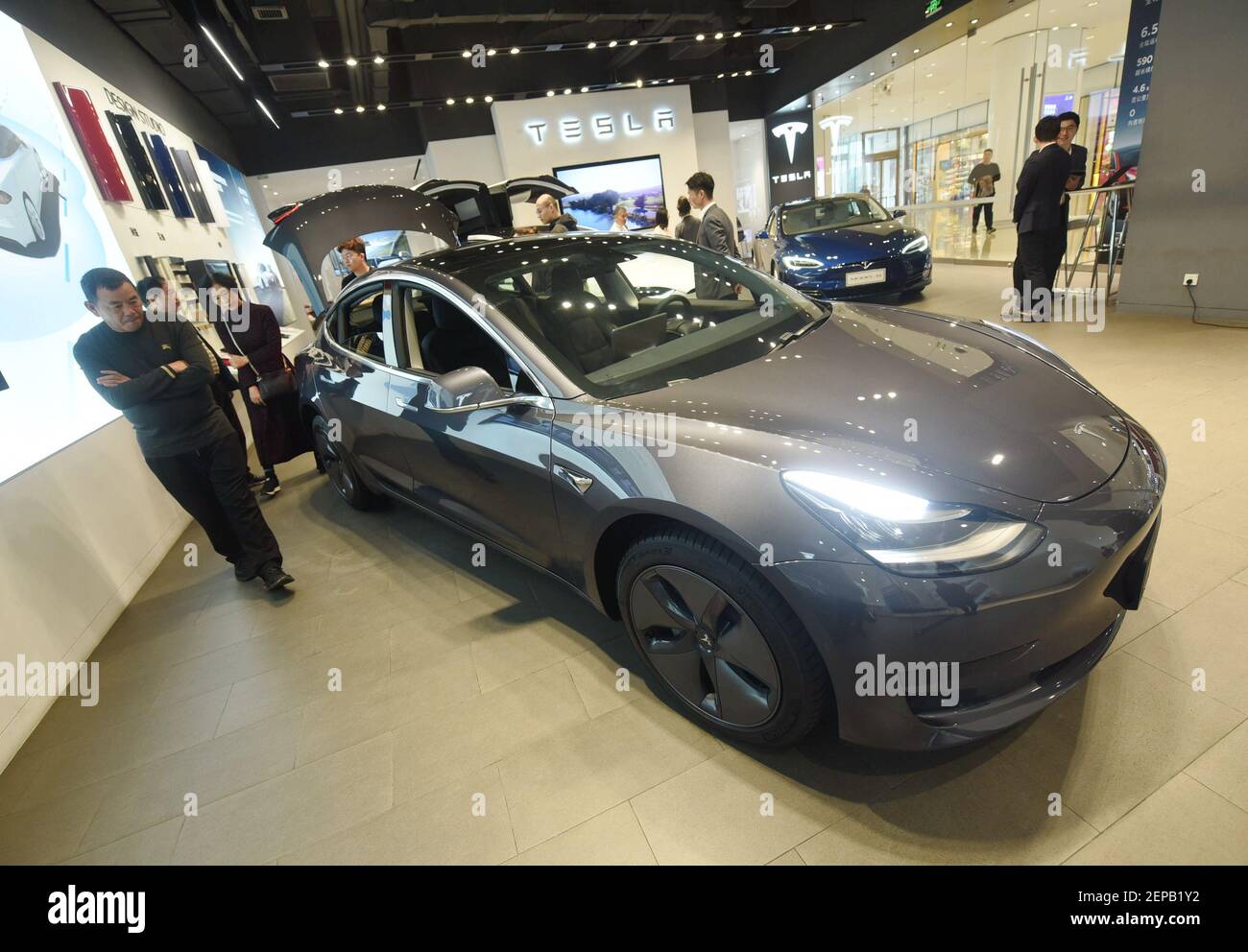 People look at a Chinese-manufactured Tesla Model 3 electric car on ...