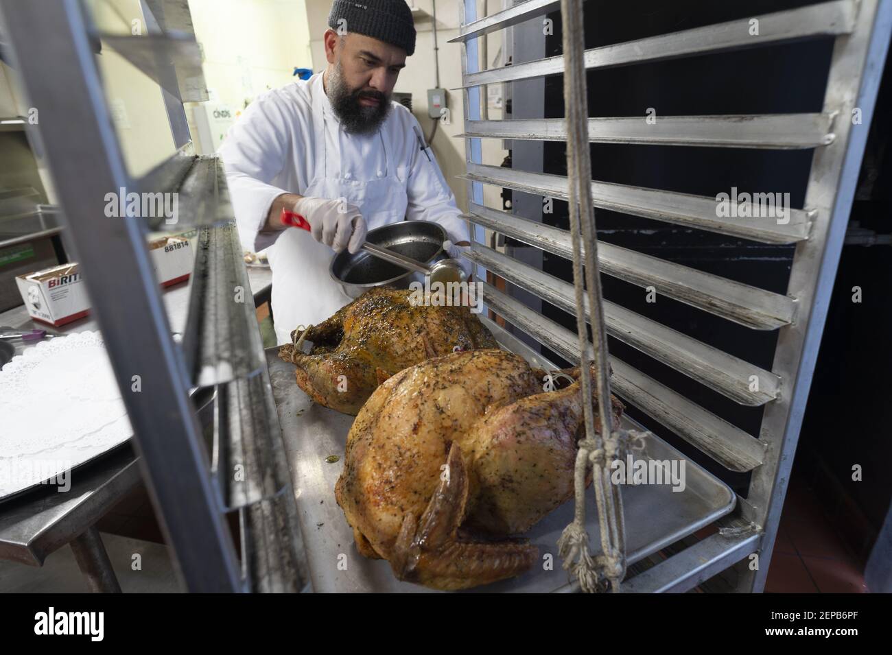 Chef Michael Smith is putting sauces and dressings on a turkey before ...