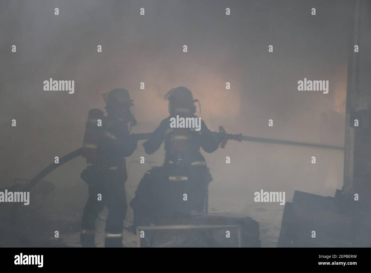 Firemen work to put a fire at a warehouse in Yulin city, south China's ...
