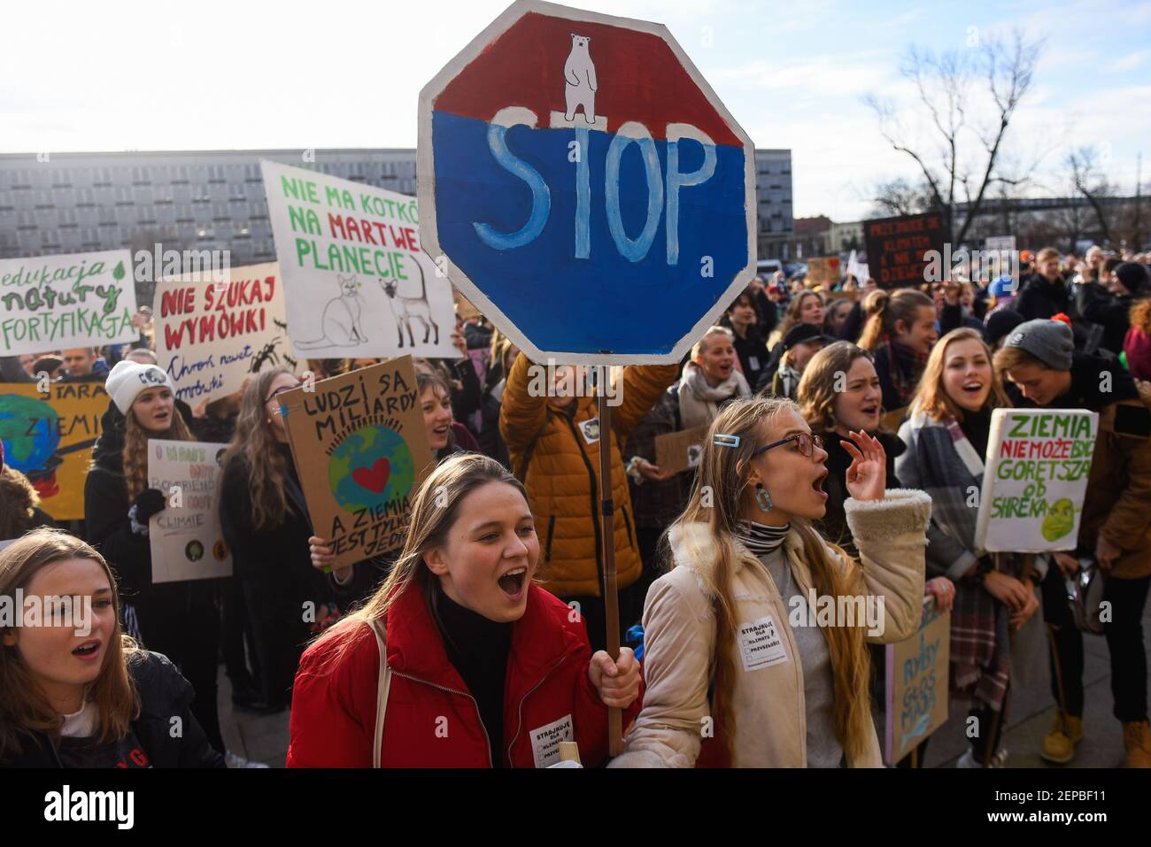 Students, parents and activists chant slogans while holding placards ...
