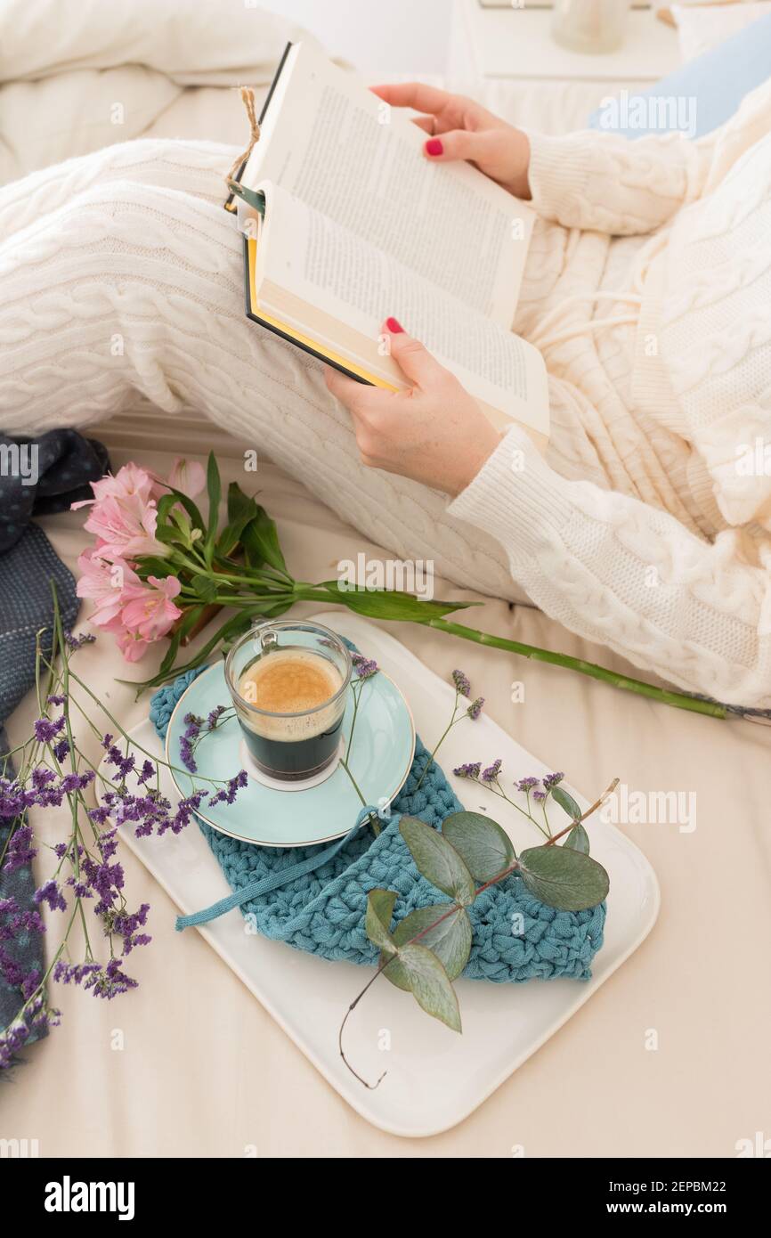 Woman reading on bed next to her coffee breakfast Stock Photo - Alamy