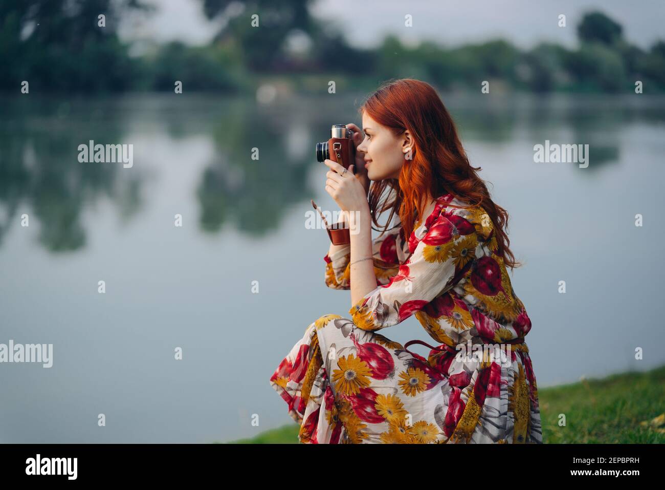 woman in a multicolored dress with a camera in her hands outdoors Stock ...