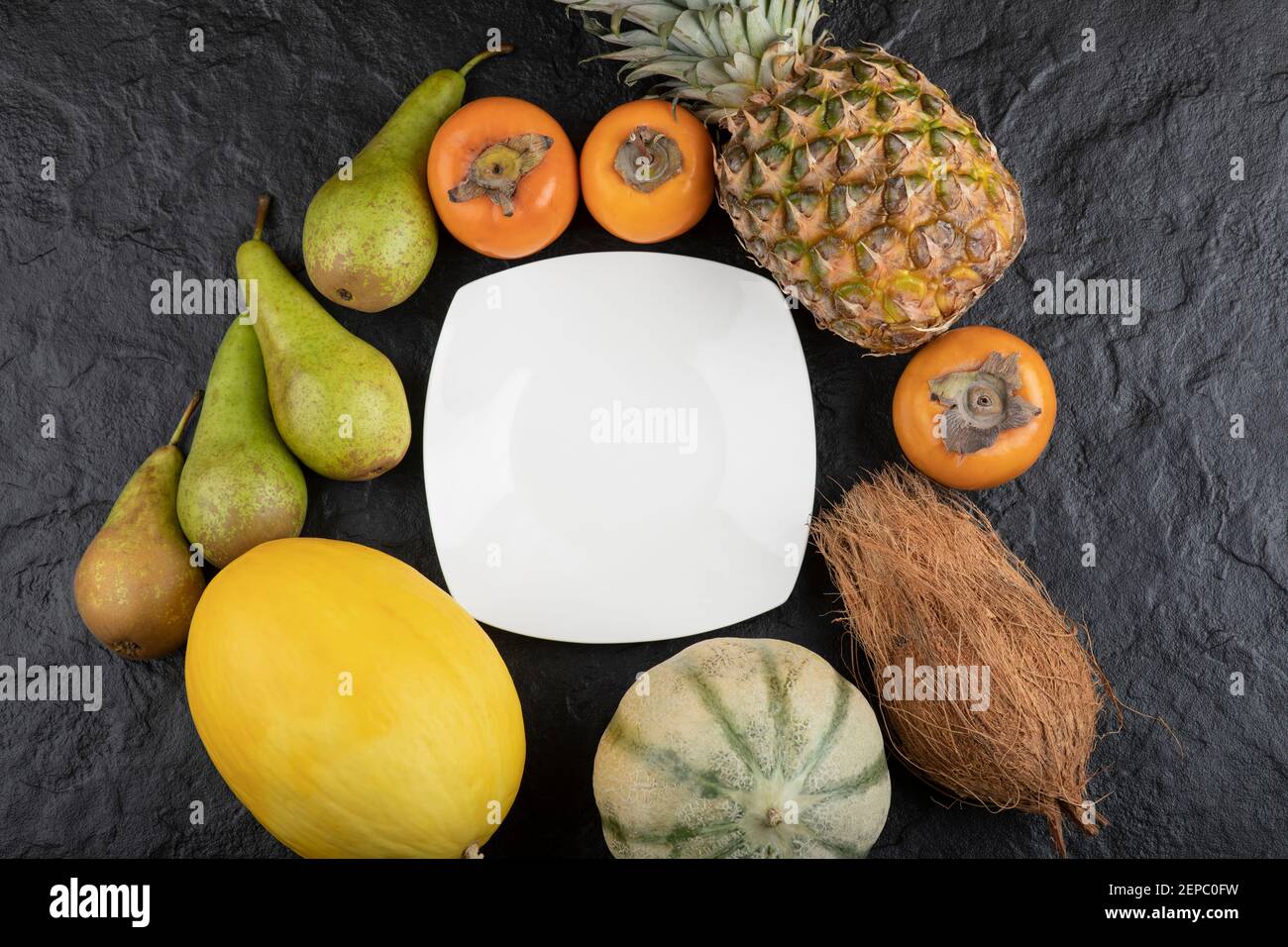 Bunch of delicious fresh fruits and empty plate on black surface Stock ...